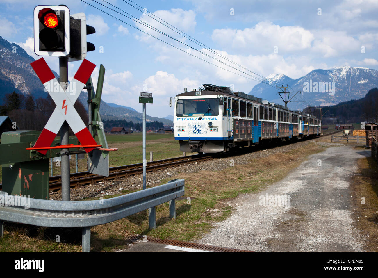 The Bayerische Zugspitzbahn train passes a level crossing in ...