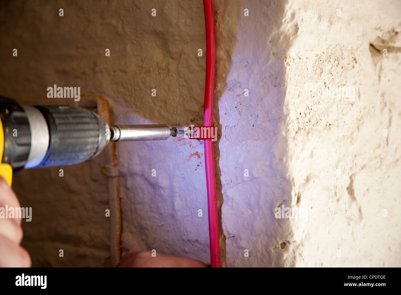 1st fix of electrical cables for a fire alarm being clipped and screwed ...