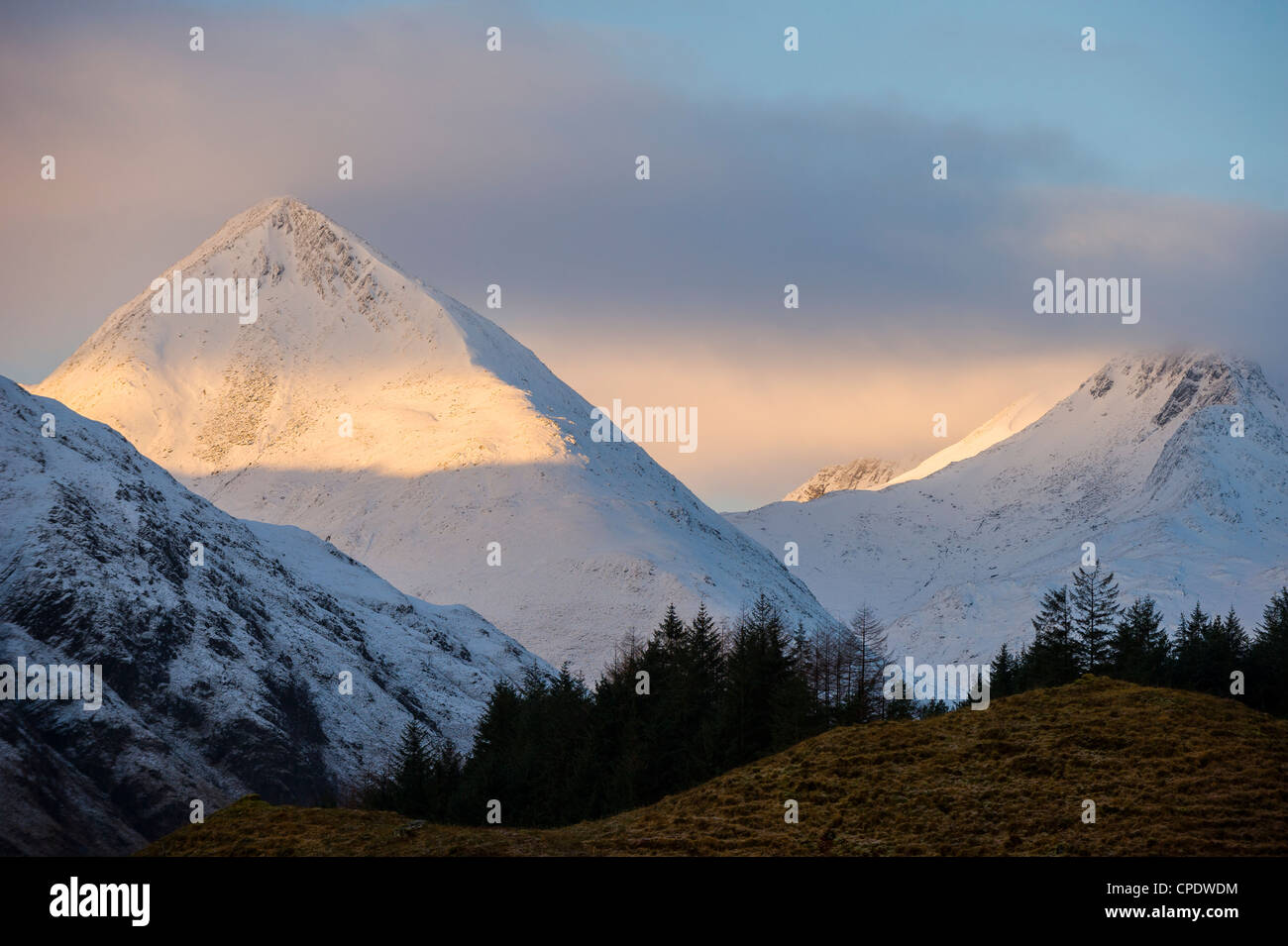 Shaft of golden sunlight on a snowy covered mountain, Glen Sheil ...