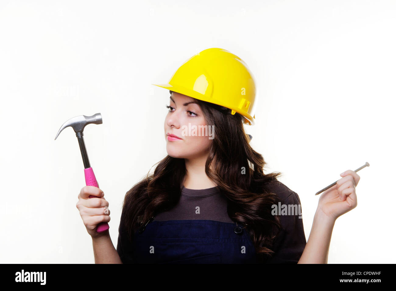 young woman with a hard hat and hammer getting ready to do some DIY ...