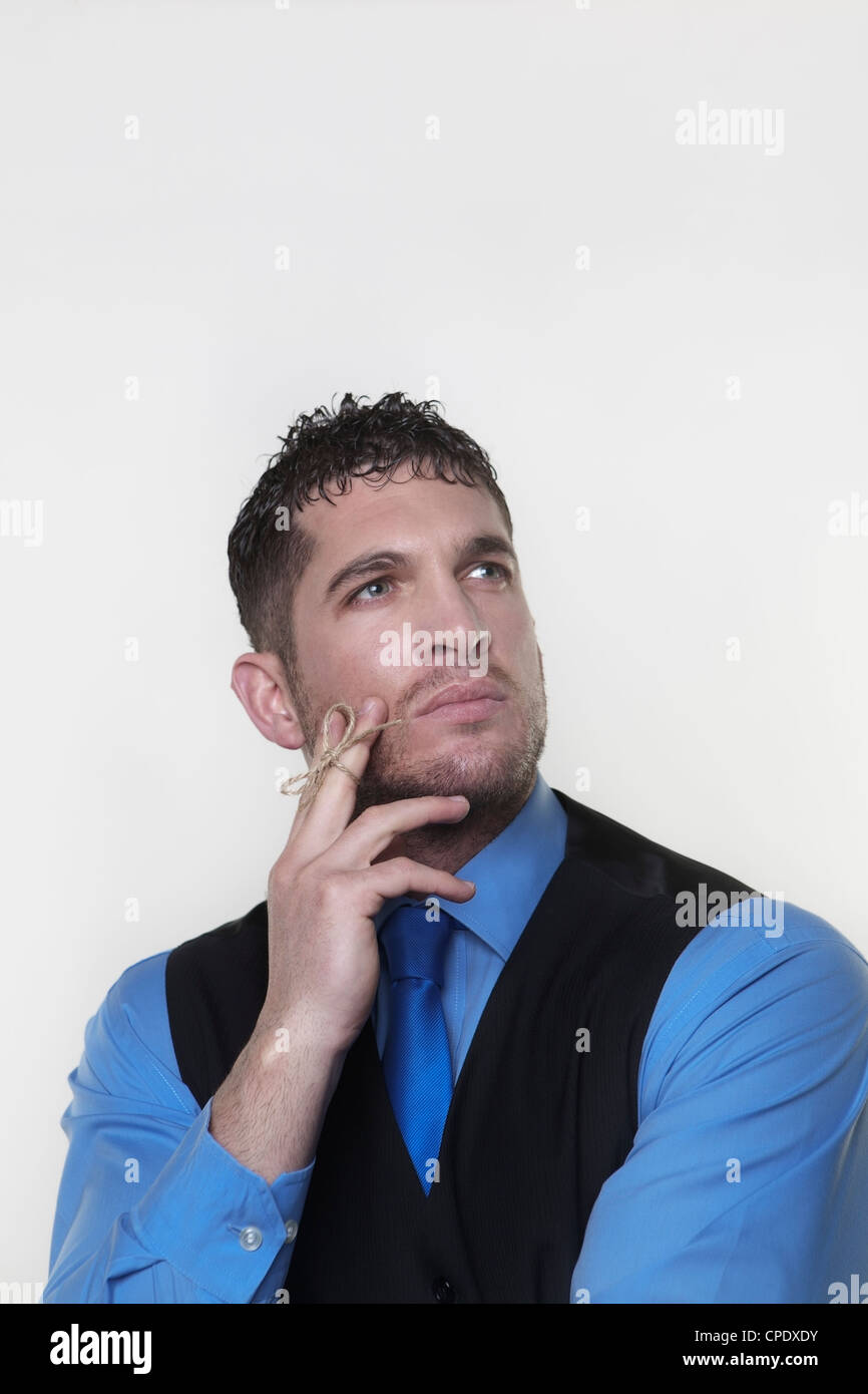 handsome business man with a piece of string tied round his finger so ...