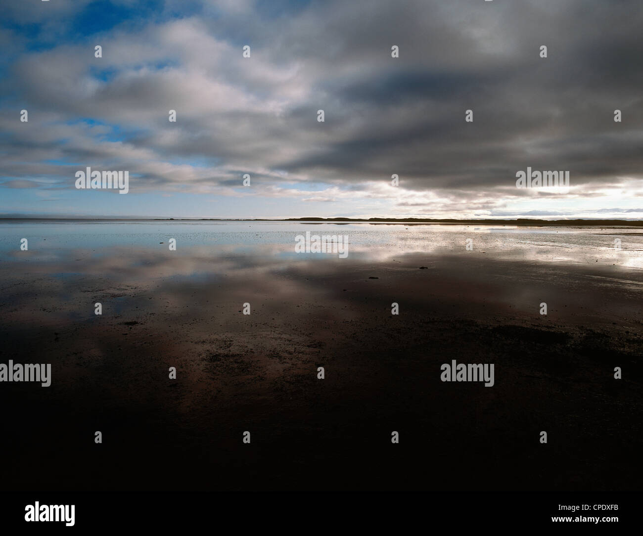 Mid-summer clouds reflect in the huge, calm salt-water lagoon at ...