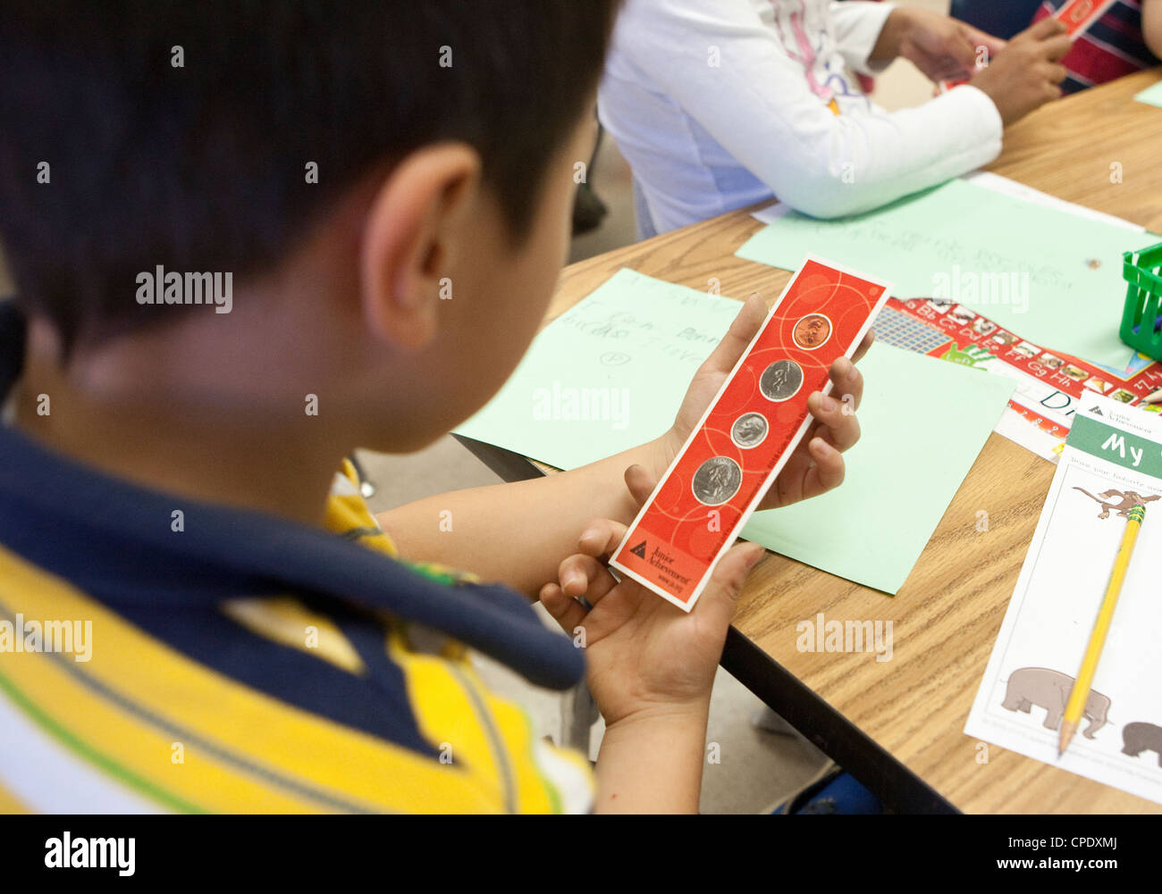 Kindergarten student reviews photos of different US coins in his ...