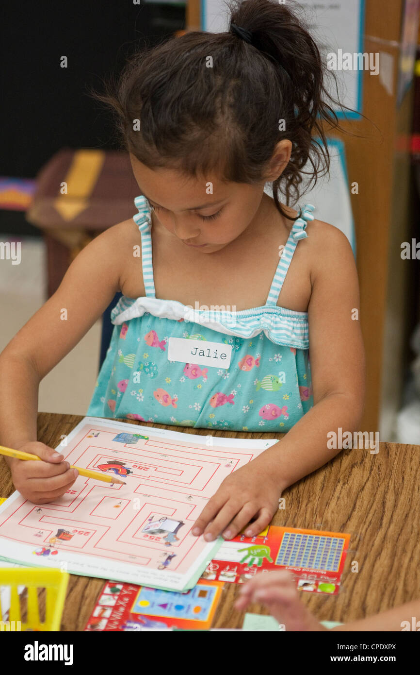 Female kindergarten student follows maze at her classroom desk at Texas ...