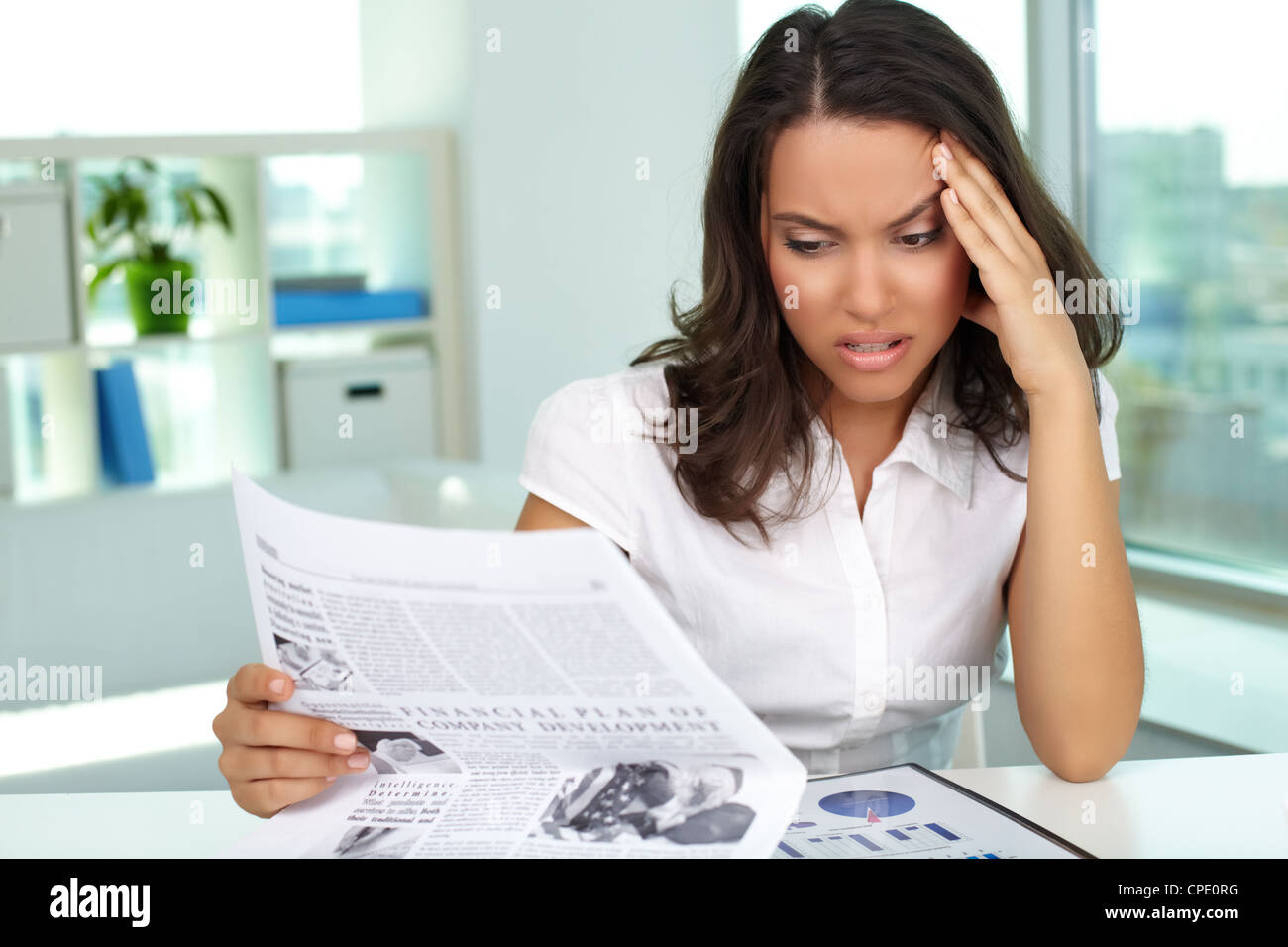Portrait of unhappy business lady reading newspaper in office Stock ...