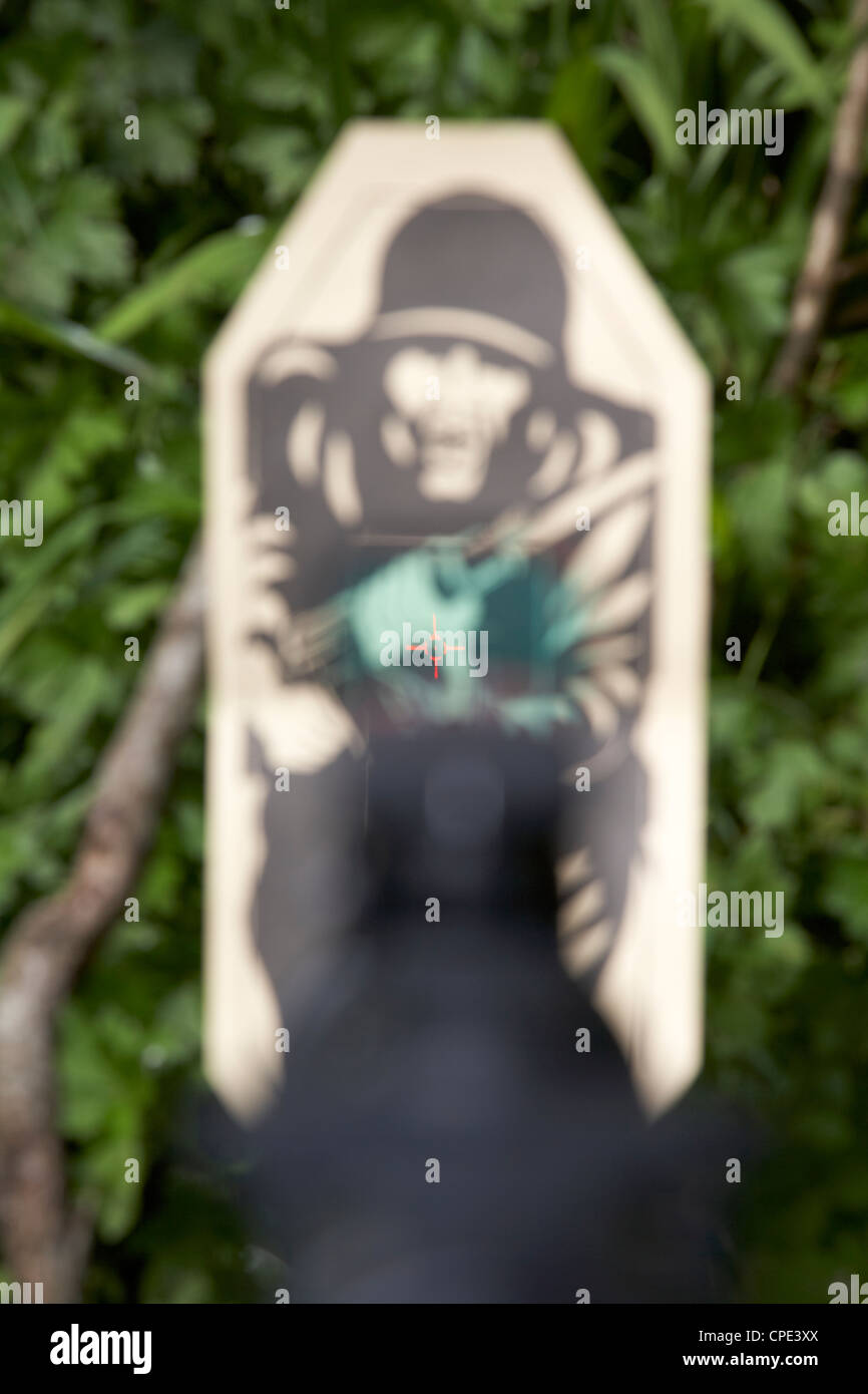 aiming an m4 rifle red dot scope at a paper target on a firing range ...