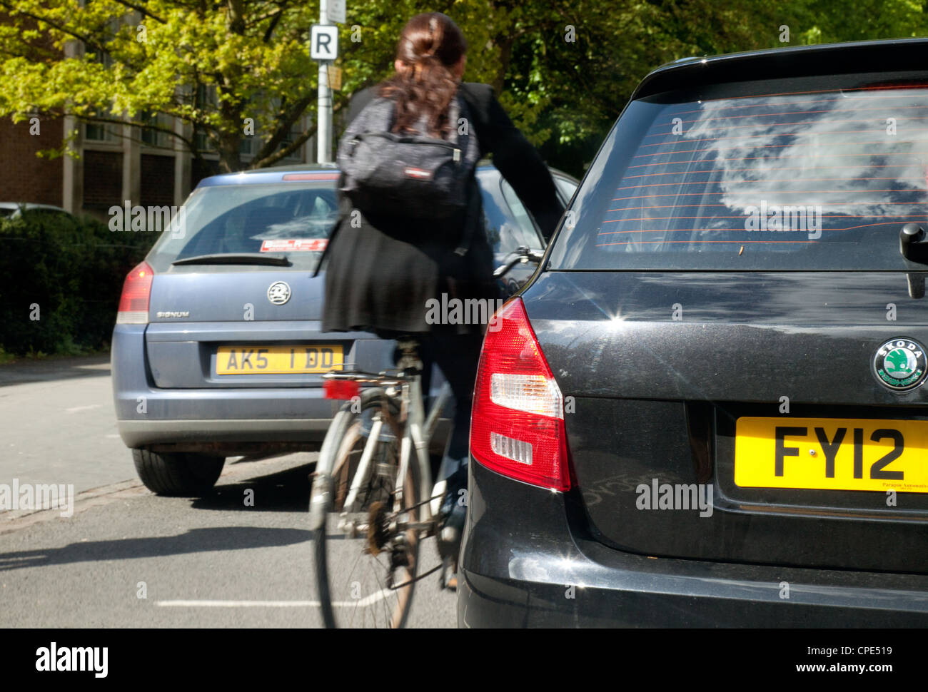 A car overtaking woman riding bicycle, Cambridge city centre ...