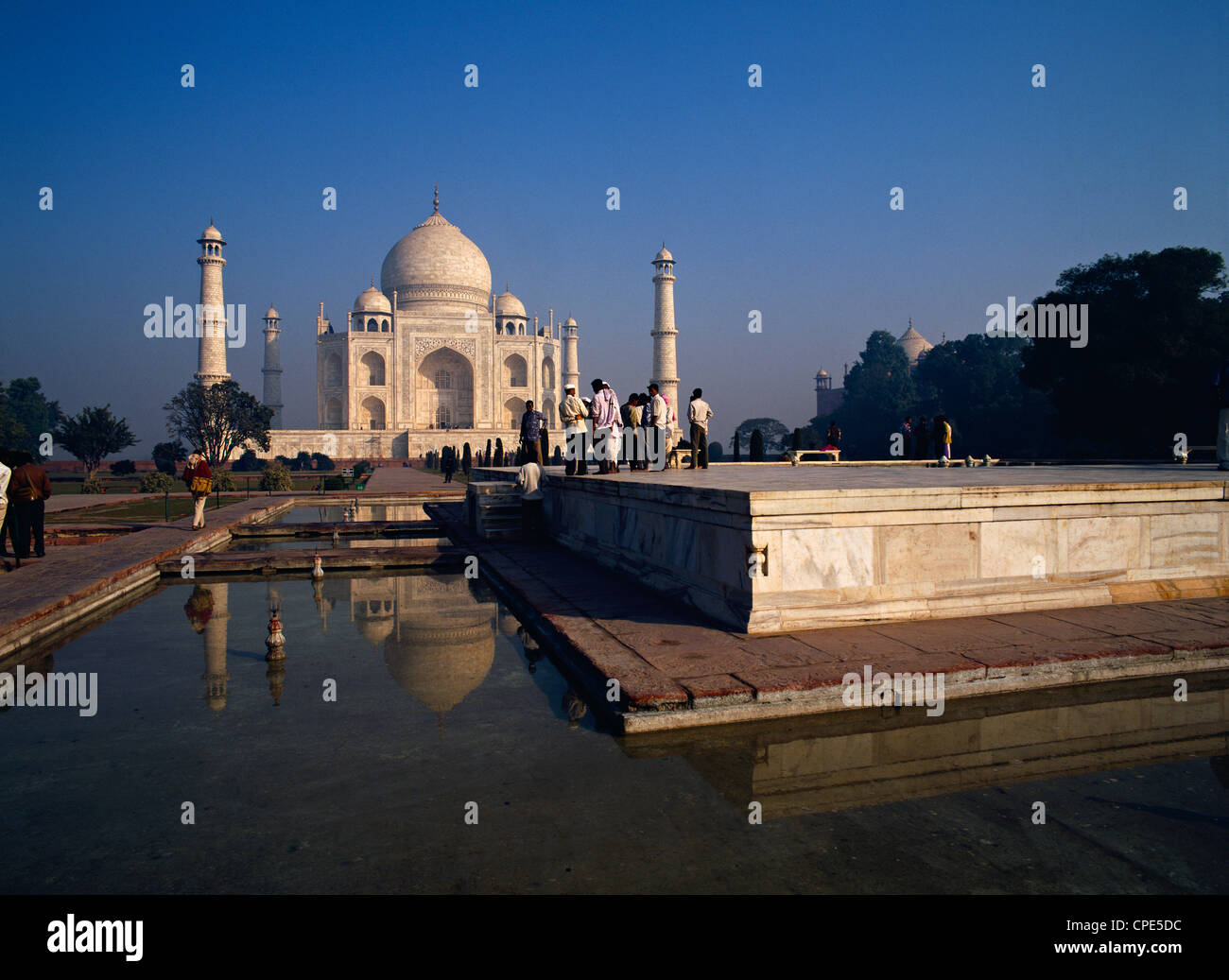 The Taj Mahal in the early morning reflects in the still water of a ...