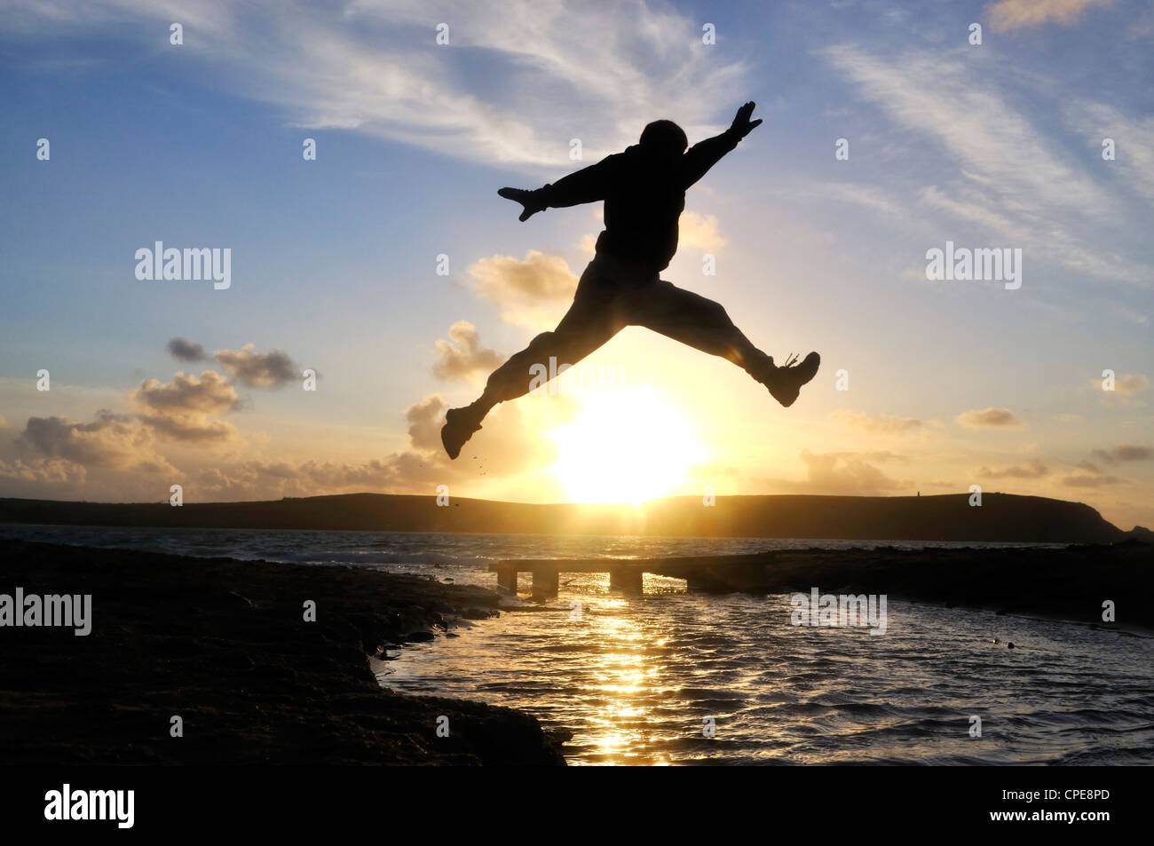 Silhouette of one man jumping over water at the beach Stock Photo - Alamy