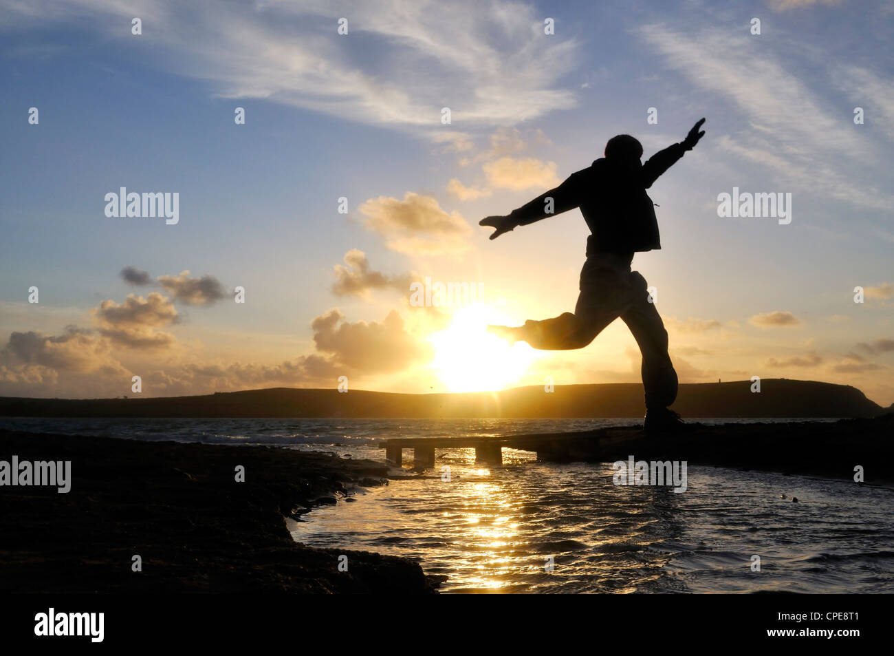 Silhouette of one man jumping over water at the beach Stock Photo - Alamy