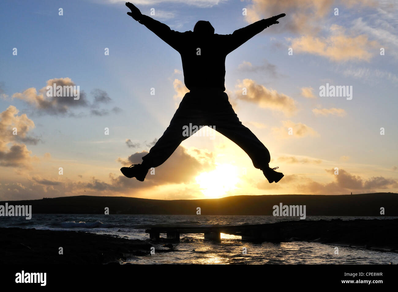 Silhouette of one man jumping over water at the beach Stock Photo - Alamy