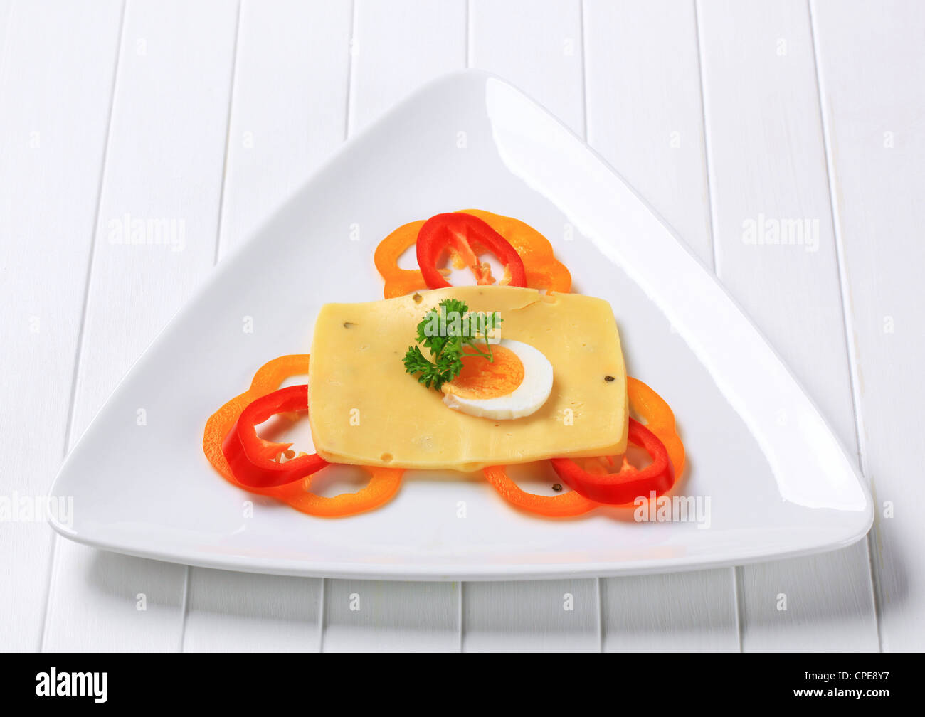 Slice of cheese and pepper on plate Stock Photo - Alamy