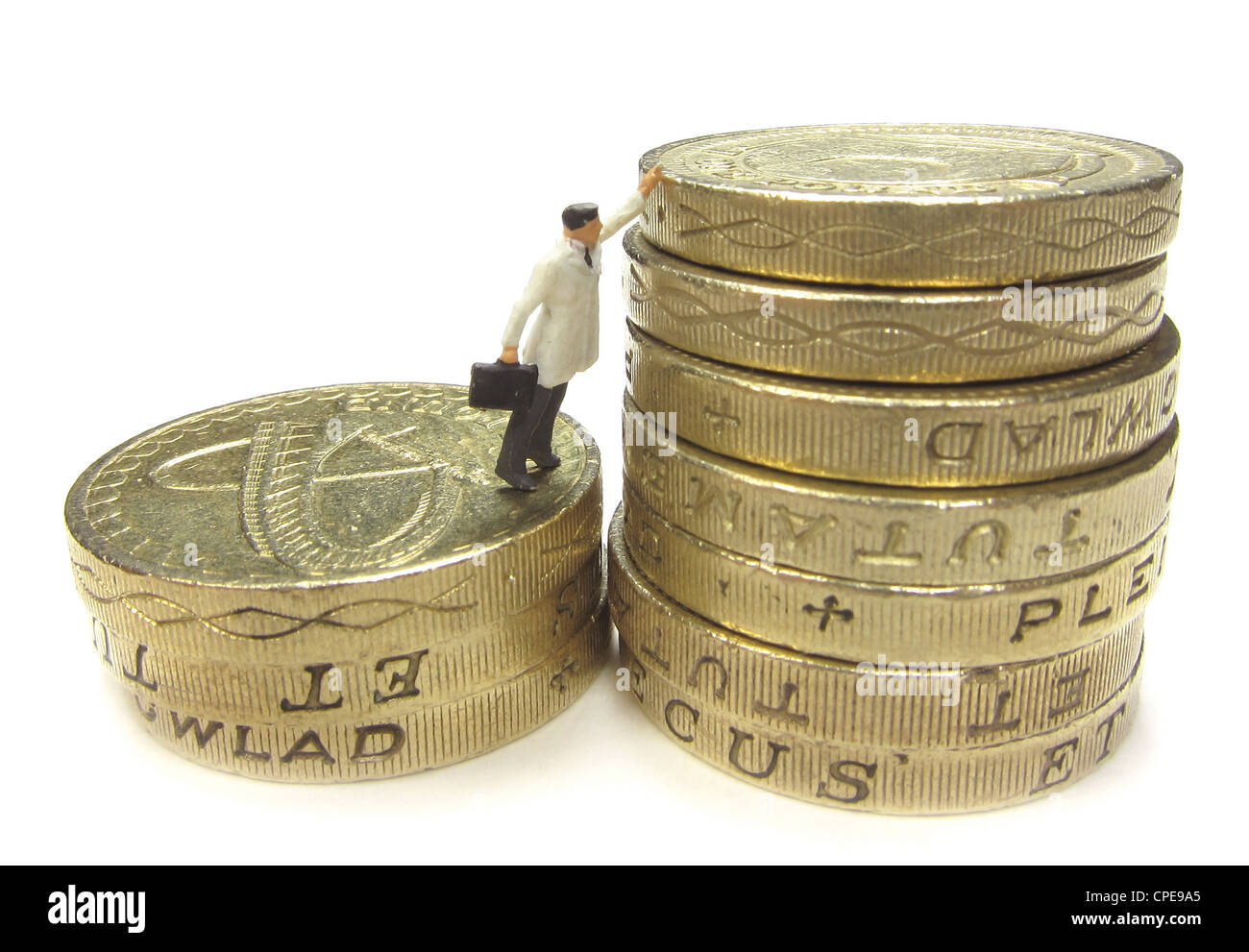 Miniature businessman climbing a stack of coins Stock Photo - Alamy