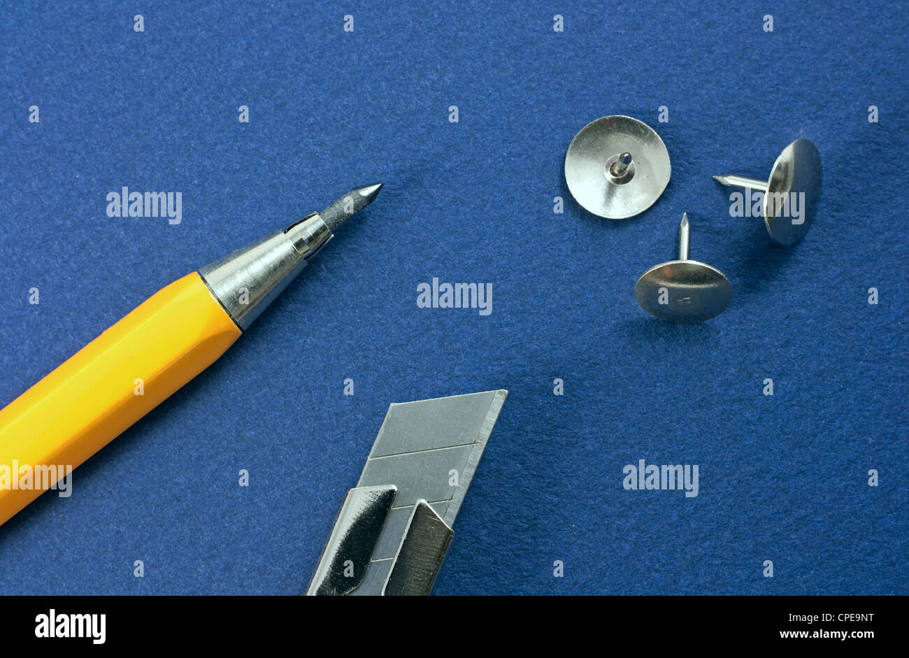 Retractable blade knife, mechanical pencil and drawing pins Stock Photo ...