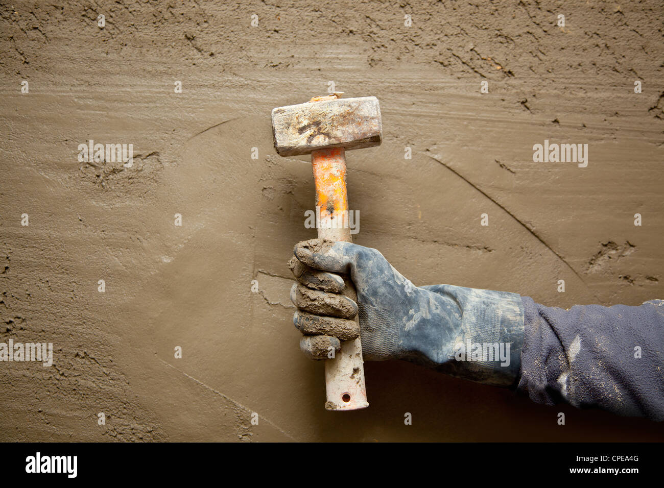hammer man hand with gloves in grunge cement mortar background Stock ...