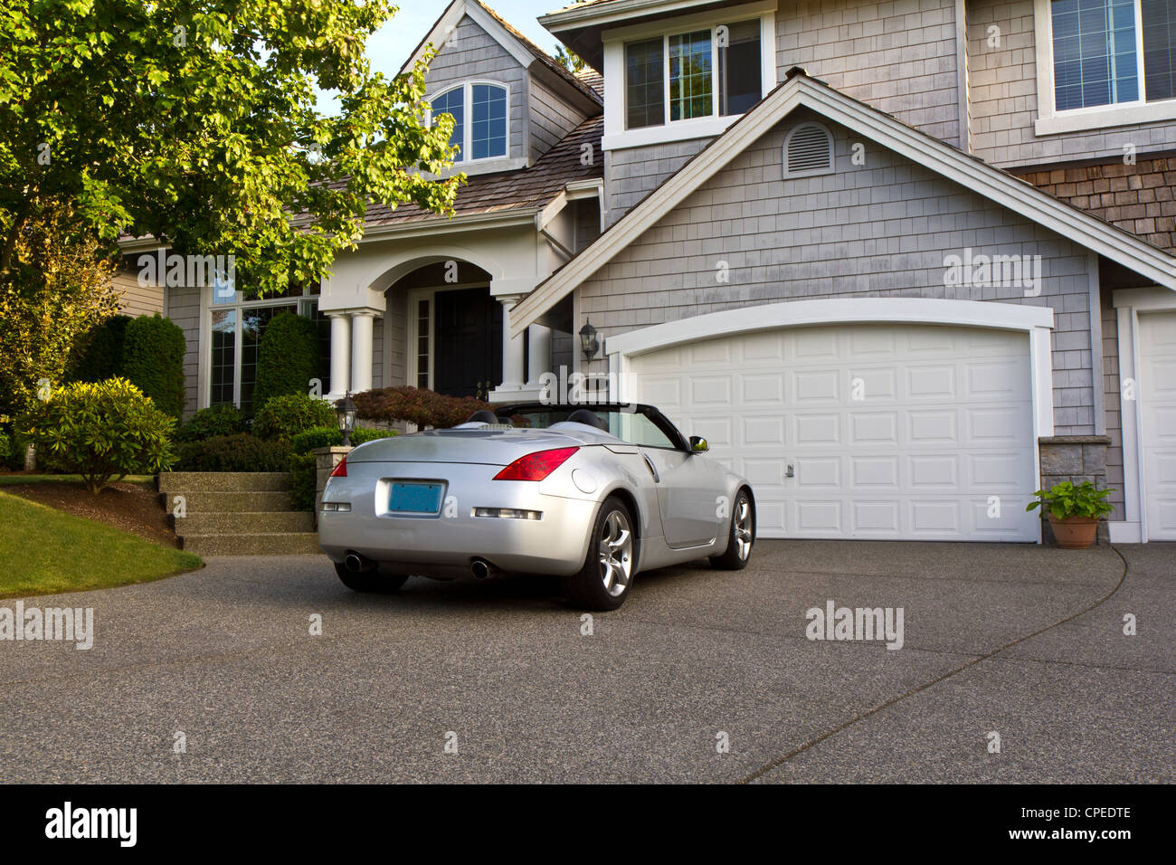 Sporty car parked in front of home during summer Stock Photo - Alamy