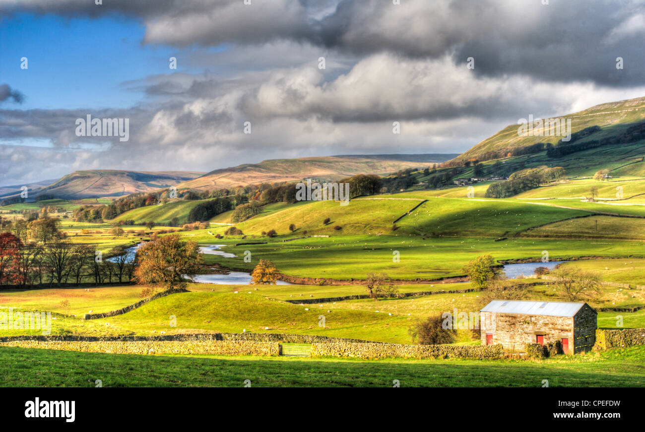 Country scene showing a river flowing past meadows with dry stone walls ...