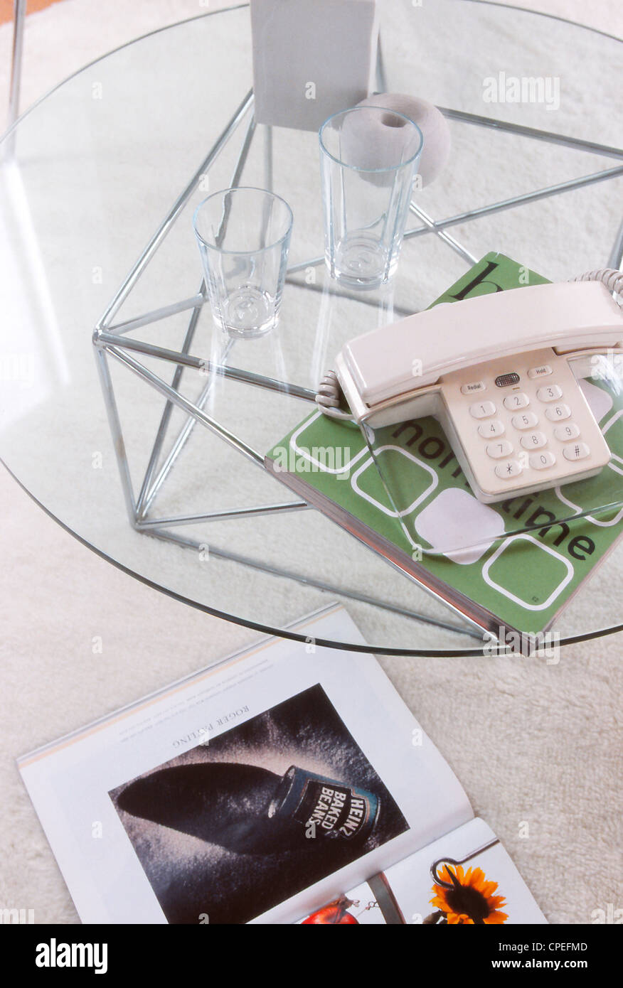 Telephone, Drinking Glass And Magazine On Circular Glass Table Stock ...
