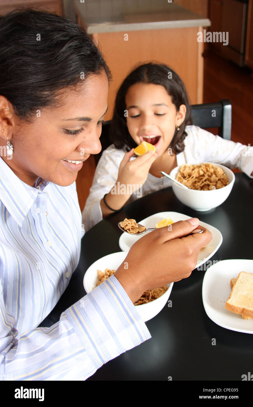 Family eating their breakfast sitting at the table Stock Photo - Alamy