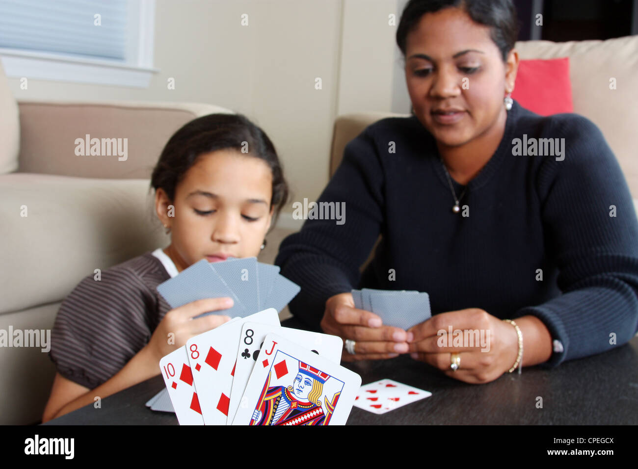 Family playing cards together around the table Stock Photo - Alamy