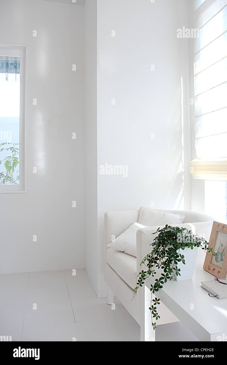 White Easy Chair And Side Table Near Window Stock Photo - Alamy