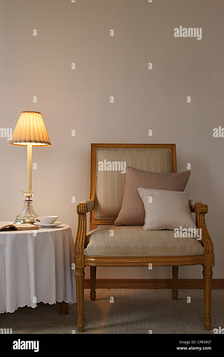 Cushion On Chair With Electric Lamp On Side Table Stock Photo - Alamy