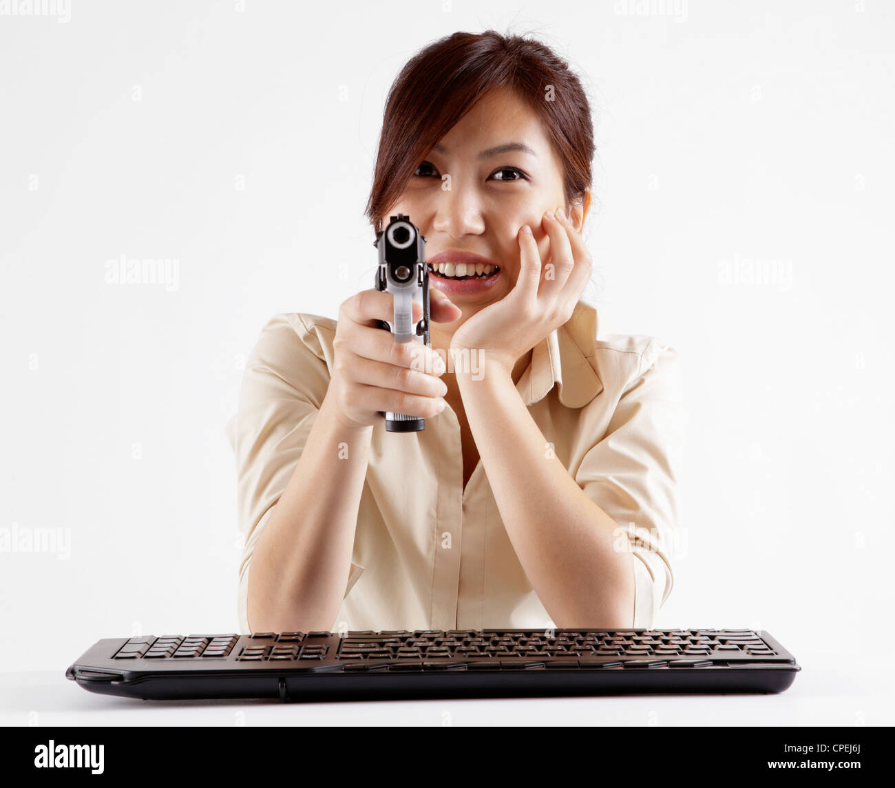 Office lady shoots gun in front of keyboard Stock Photo - Alamy