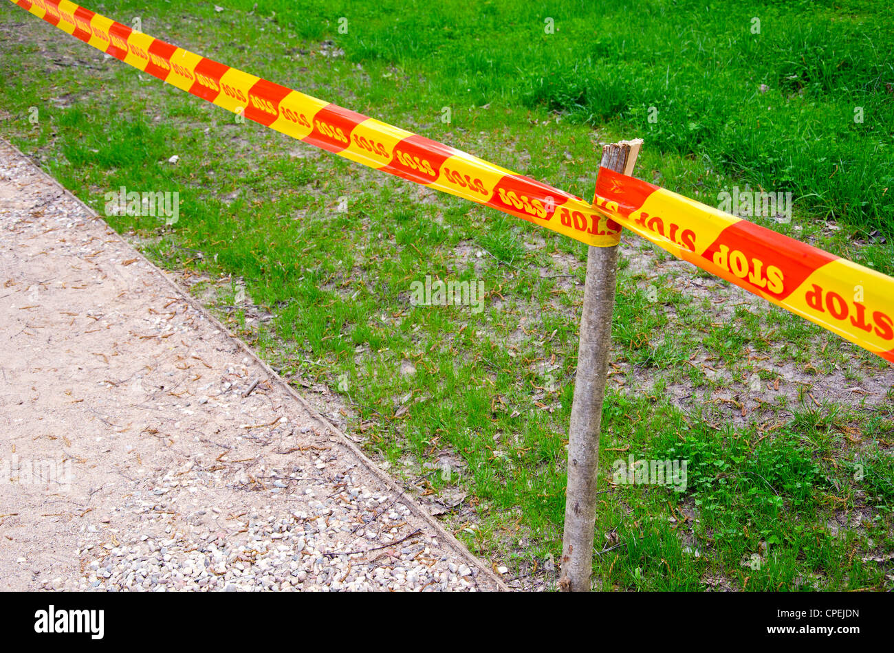 red and yellow stop ribbon in the spring park Stock Photo - Alamy