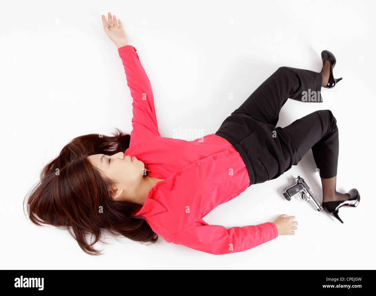 Office lady lying on ground with gun, looks like crime scene Stock ...