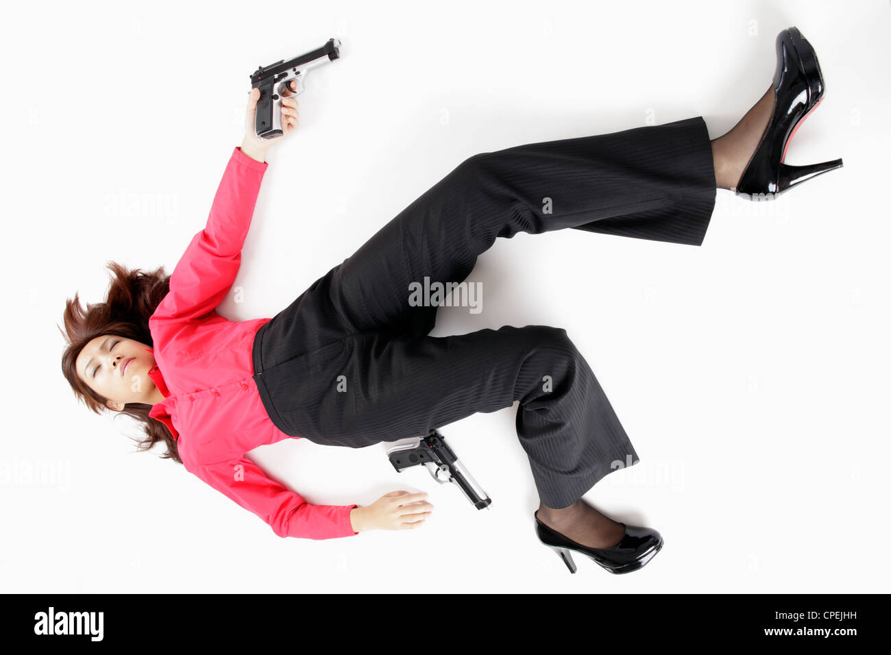 Office lady lying on ground with gun, looks like crime scene Stock ...