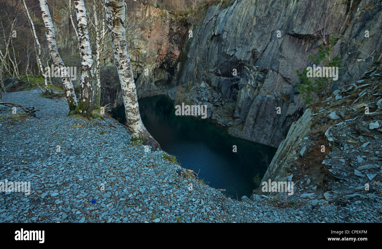 Hodge Close slate quarry water filled with broken rail red and green ...