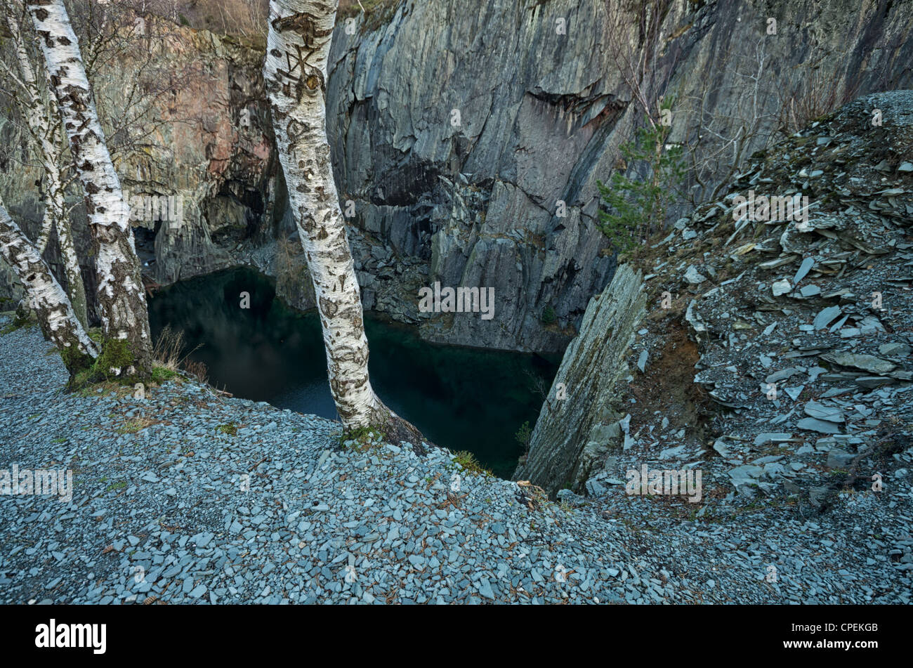 Hodge Close slate quarry water filled with broken rail red and green ...