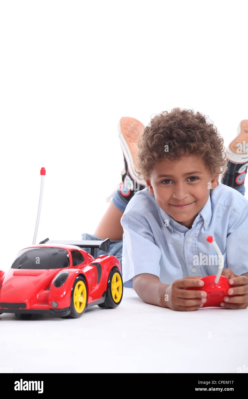 Young boy playing with a red remote control sports car Stock Photo - Alamy