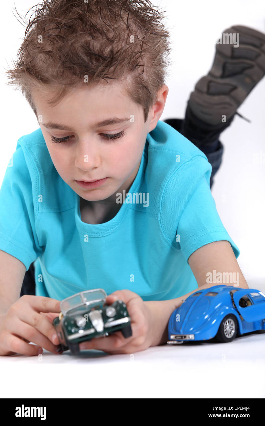 Little boy playing with toy cars Stock Photo - Alamy