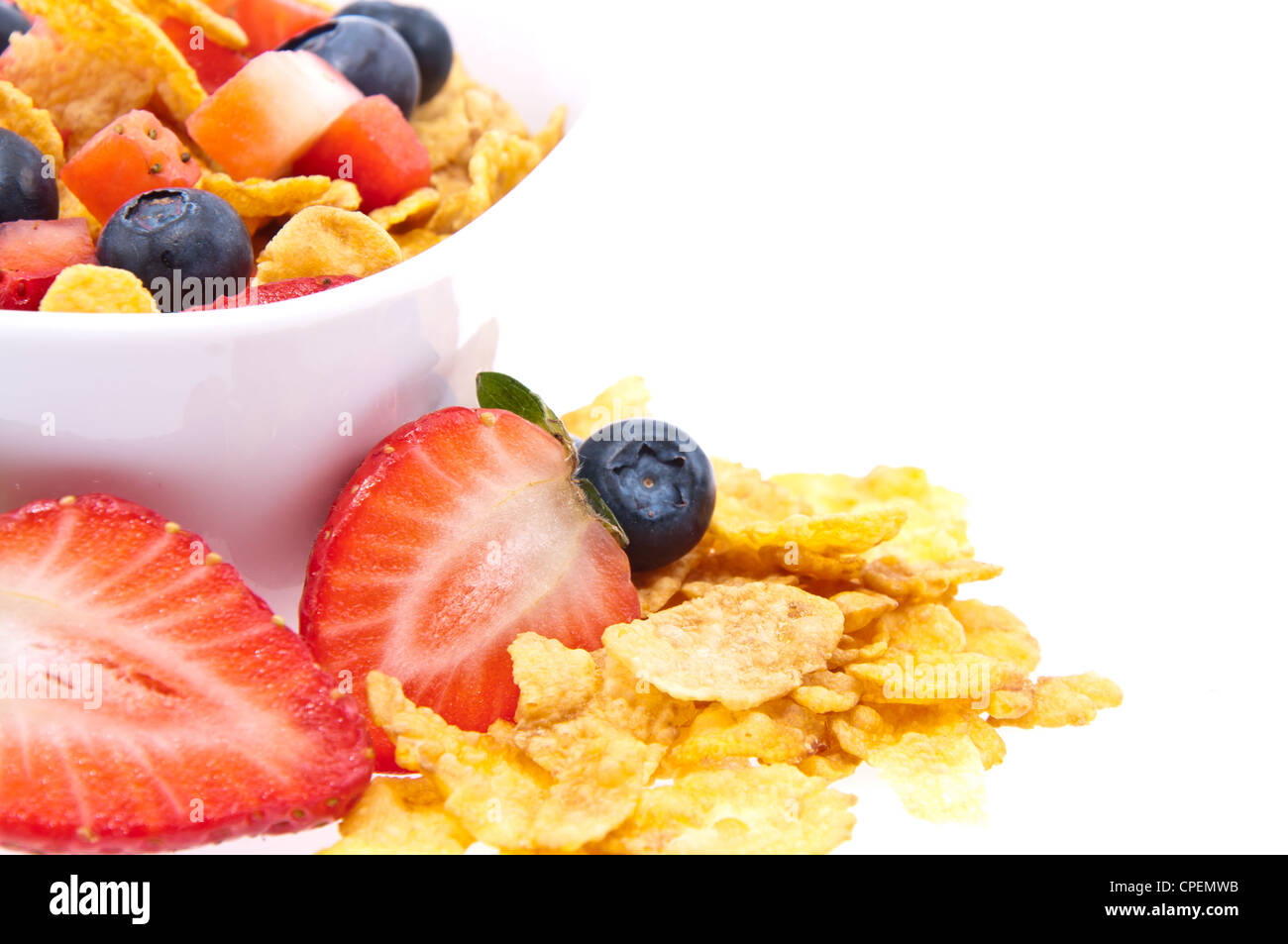 Cornflakes with fresh fruits in a bowl isolated on white background ...