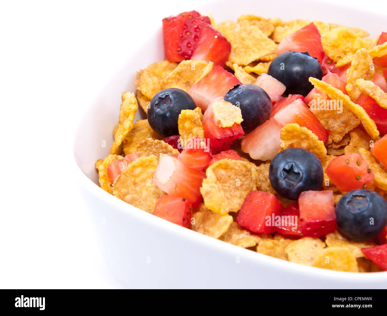 Cornflakes with fresh fruits in a bowl isolated on white background ...