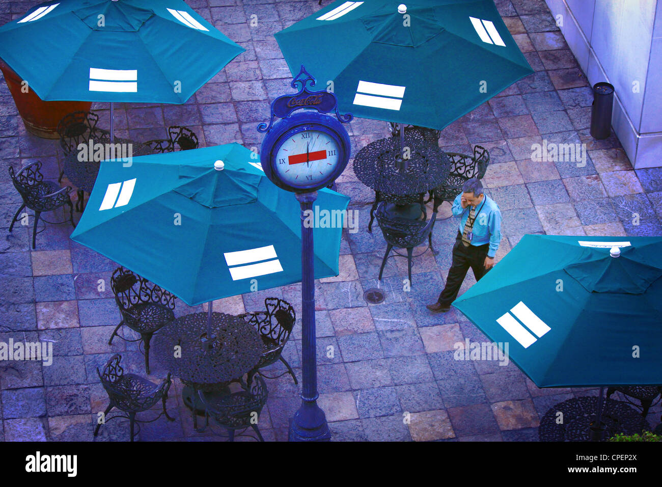 View from above of man walking in cafe with tables and cafe unbrellas ...