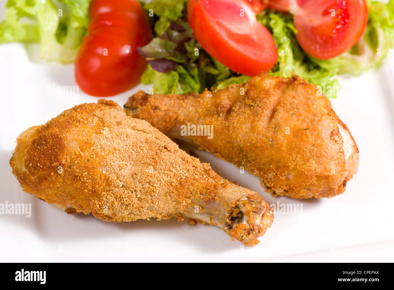 Fried chicken portion with a fresh salad Stock Photo - Alamy