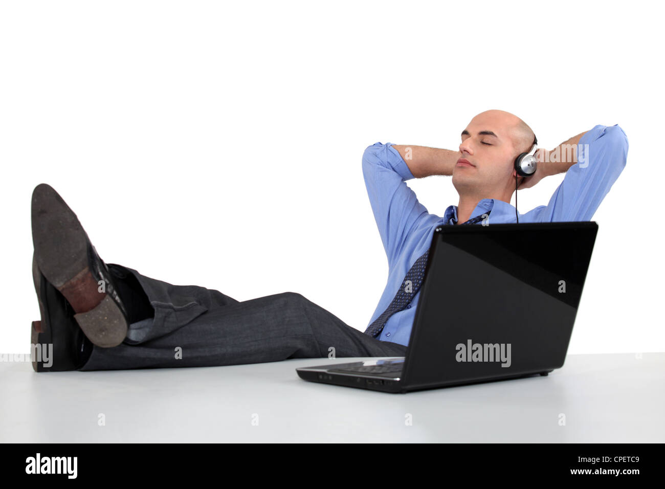 Businessman listening to music on his computer Stock Photo - Alamy