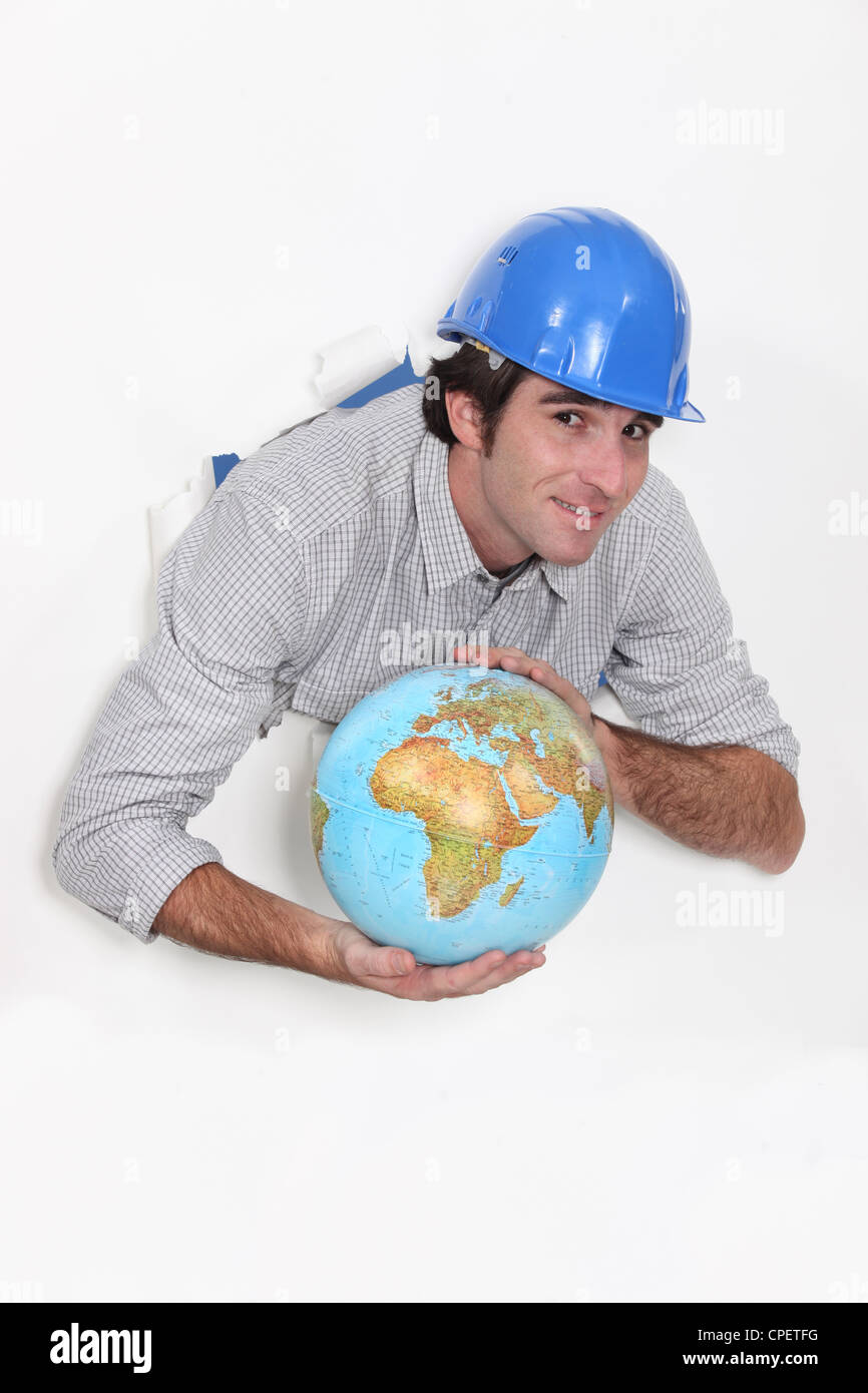 Manual worker holding globe Stock Photo - Alamy