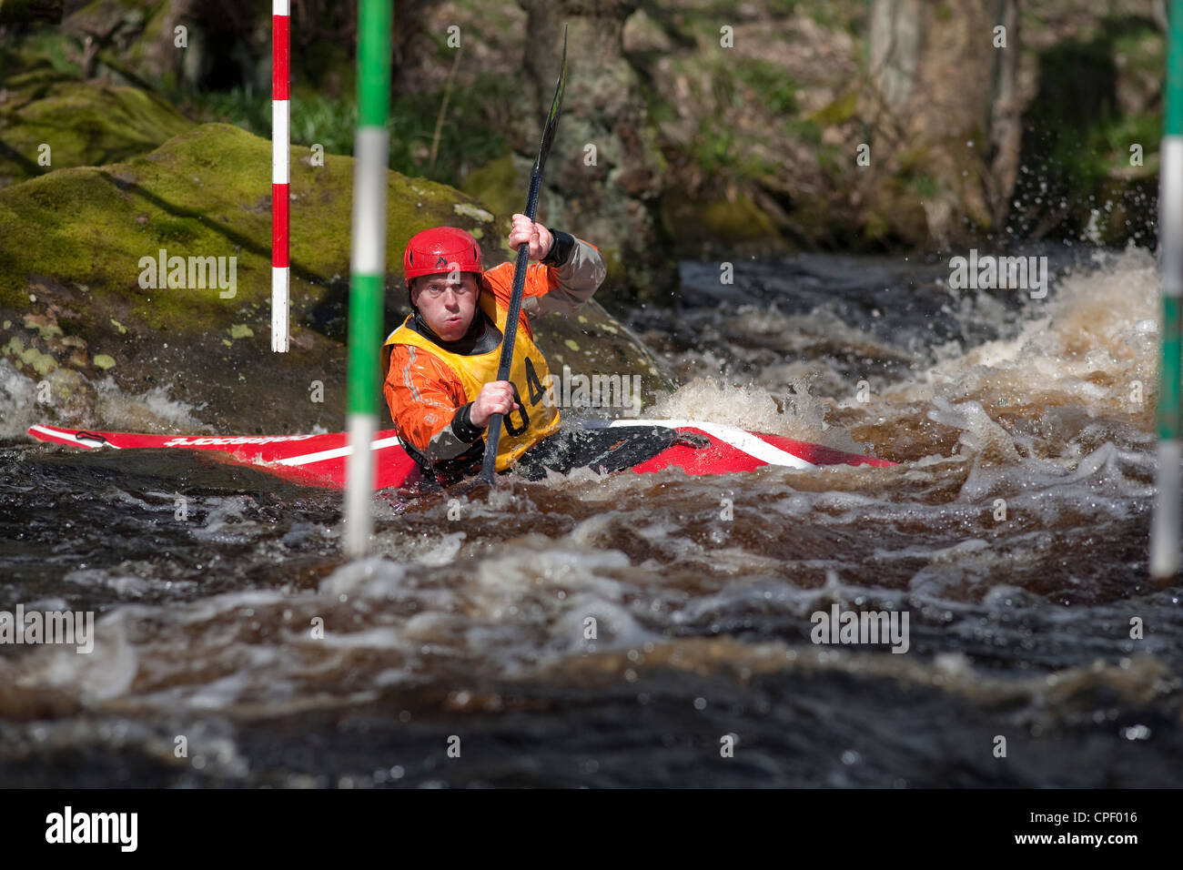 Determined and focused a male competitor in a slalom kayak competition ...
