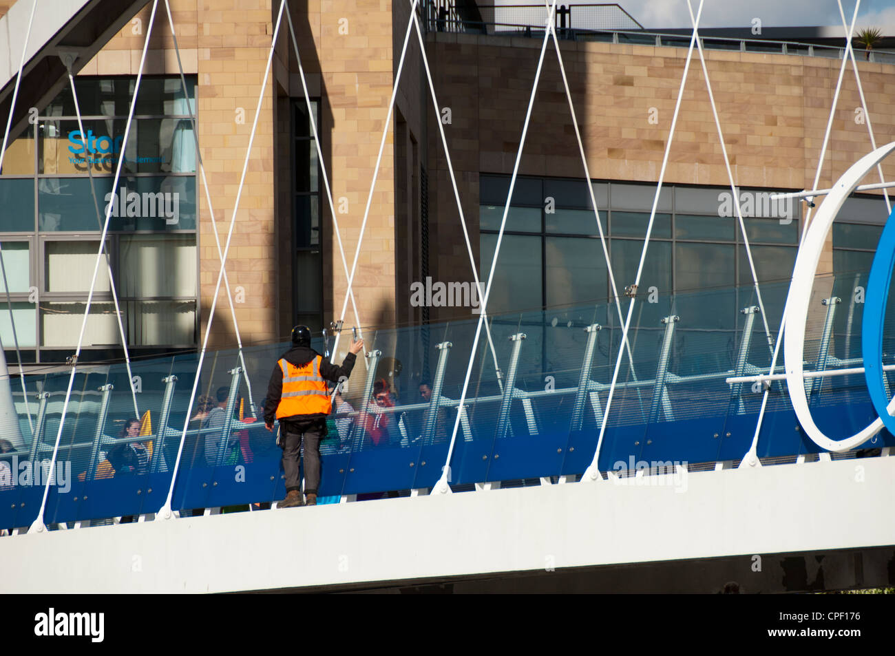 Workman on the outside of the Millennium (Lowry) footbridge, Salford ...
