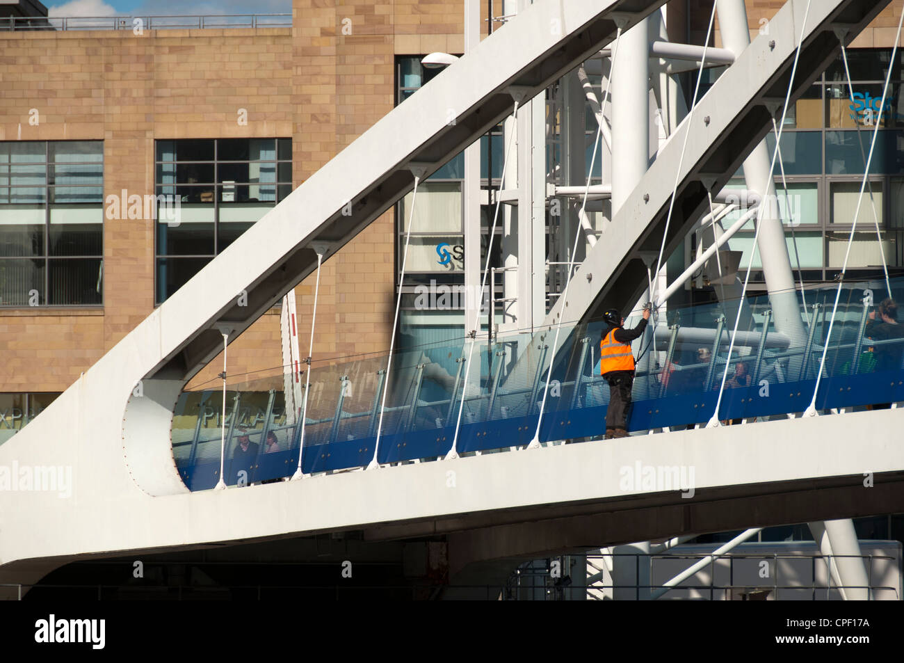 Workman on the outside of the Millennium (Lowry) footbridge, Salford ...