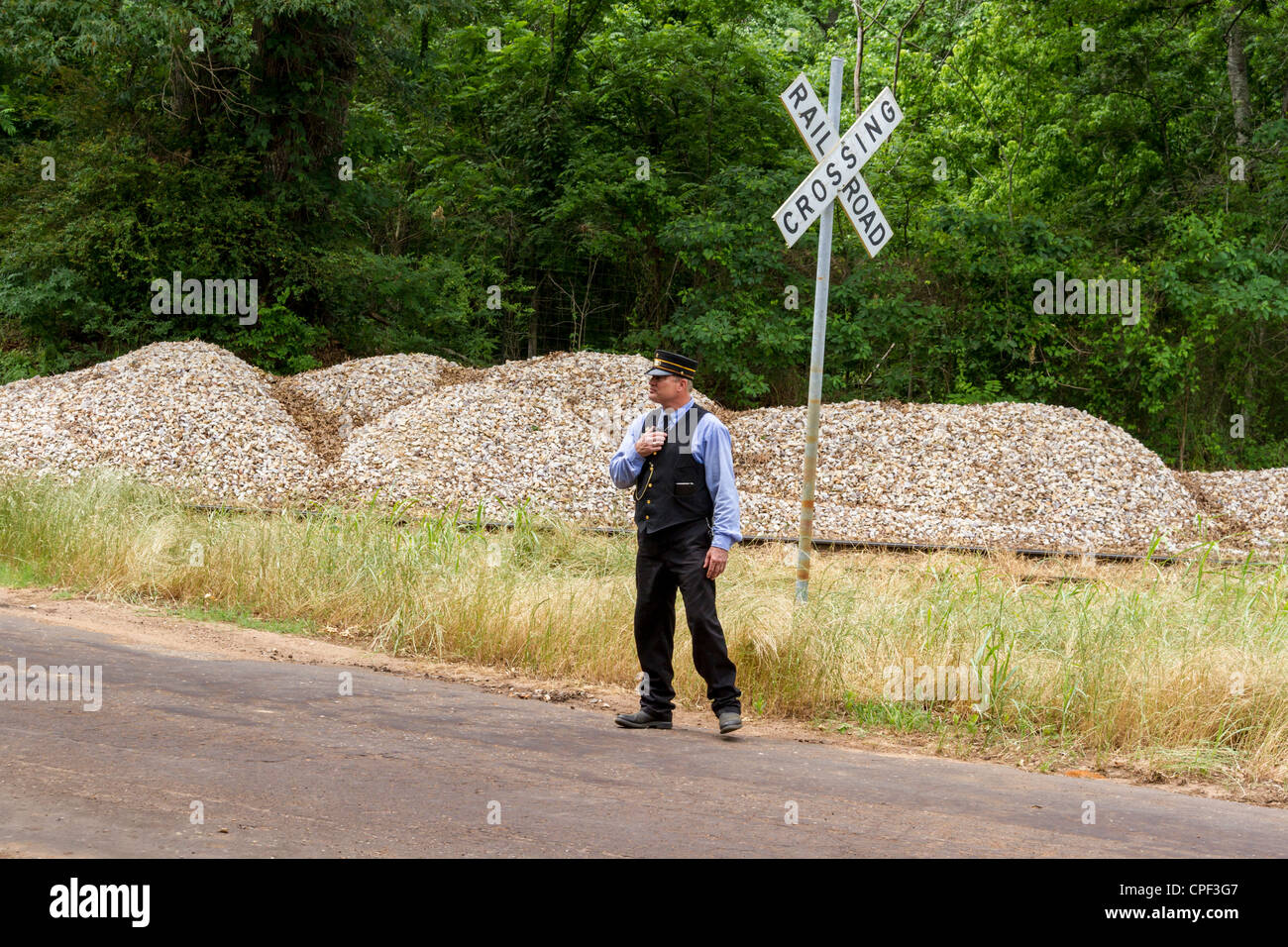 Conductor at railroad crossing waiting for steam engine locomotive ...