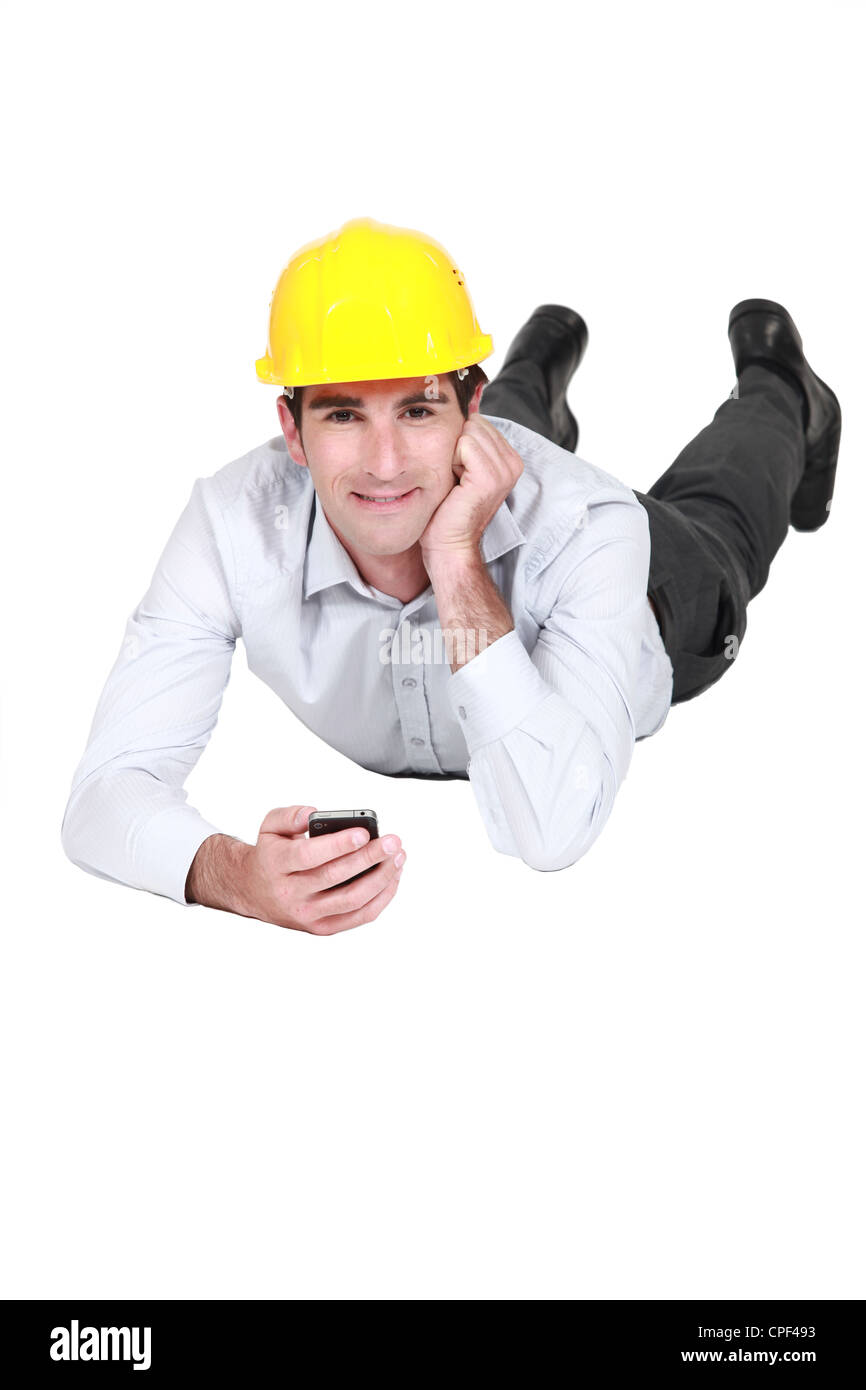 Architect laying down with mobile telephone Stock Photo - Alamy