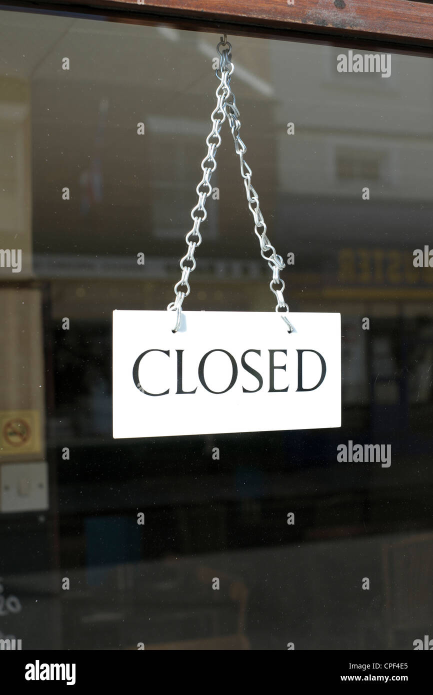 Closed sign hanging on chain in shop door window Stock Photo - Alamy