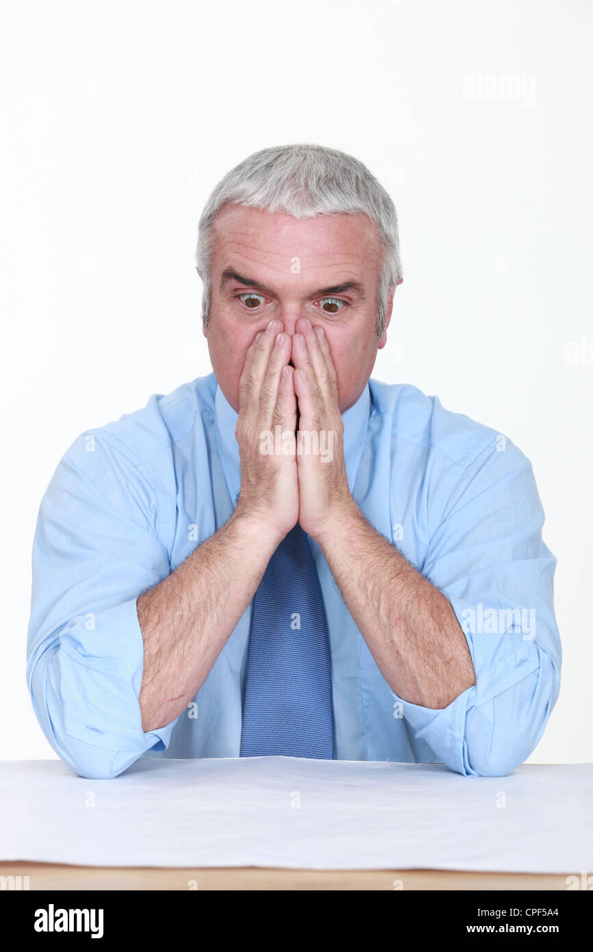 Appalled man looking at a blueprint Stock Photo - Alamy