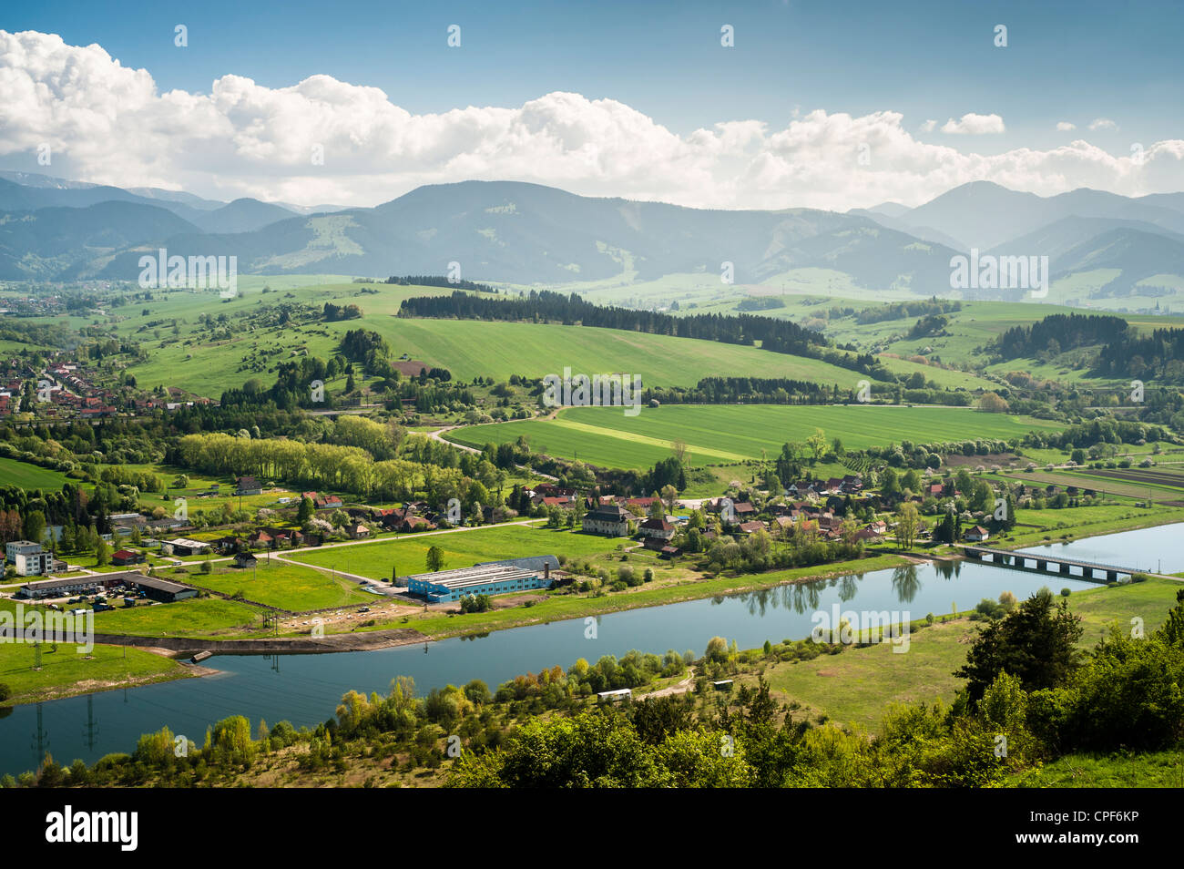 A bridge over a river in green country, with mountains and clouds Stock ...