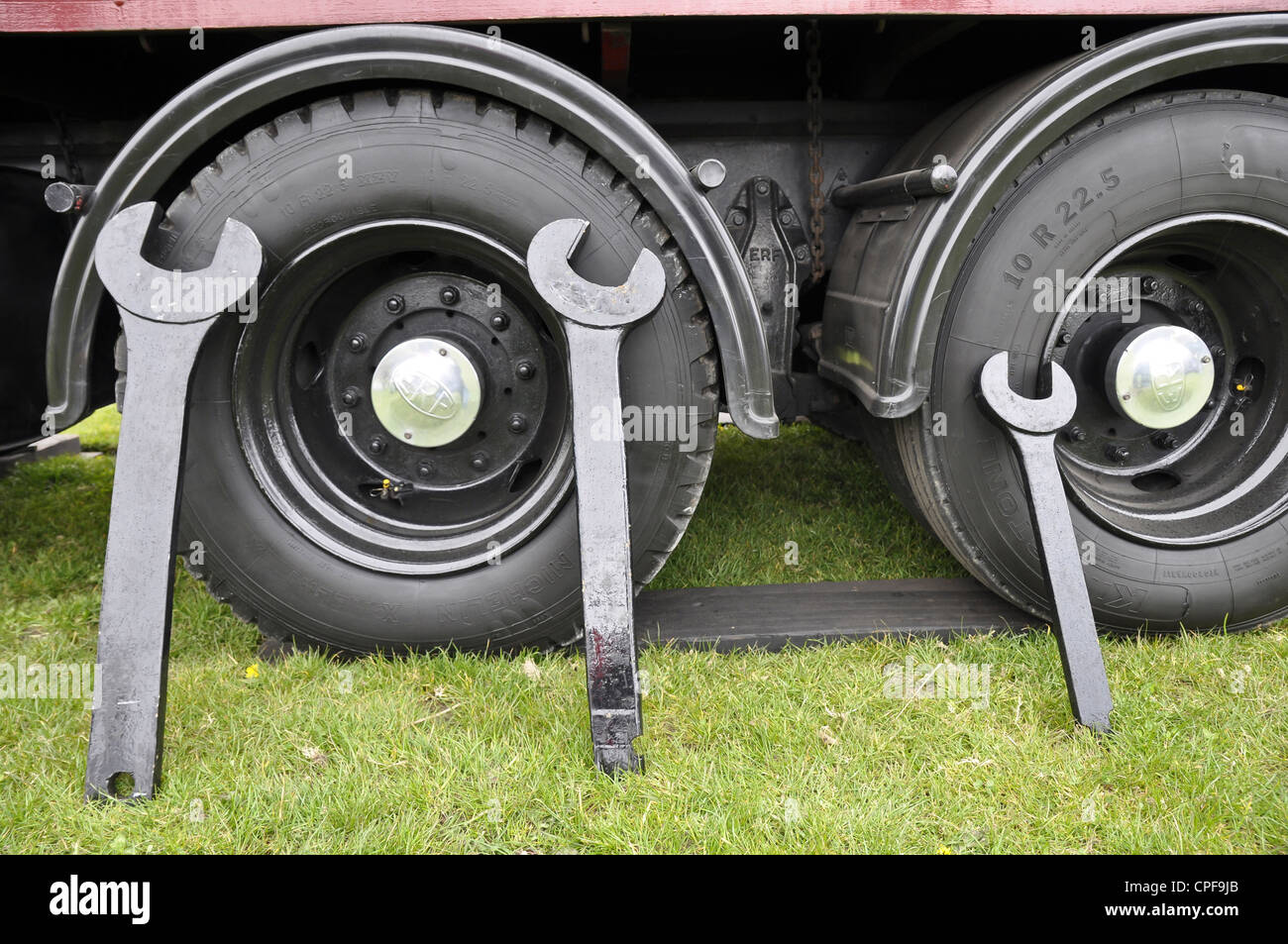 Three large spanners or wrenches leaning against wagon wheels Stock ...