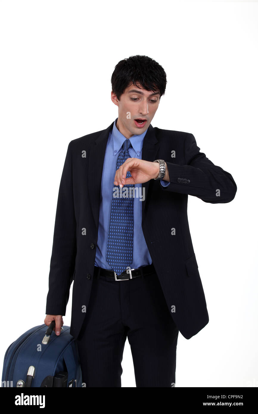Businessman with luggage realizing he is late Stock Photo - Alamy